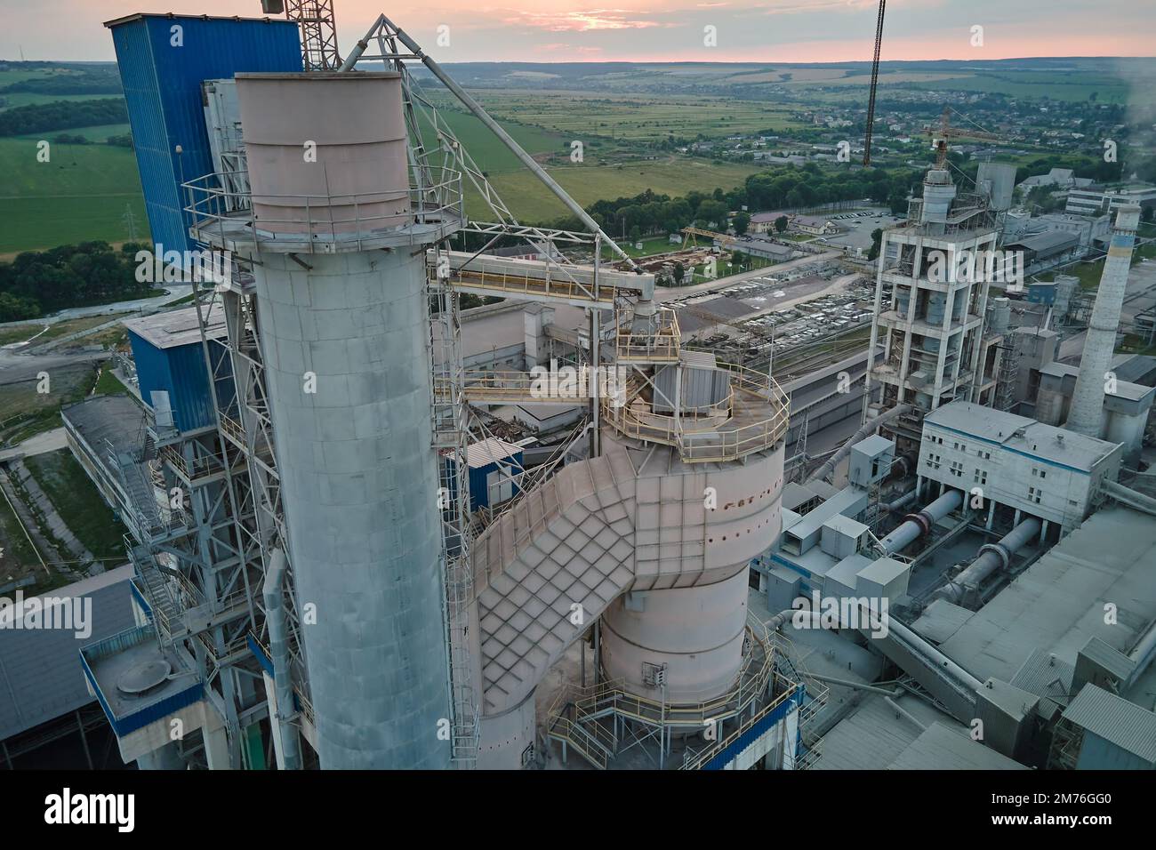 Cement plant with high factory structure and tower cranes at industrial ...