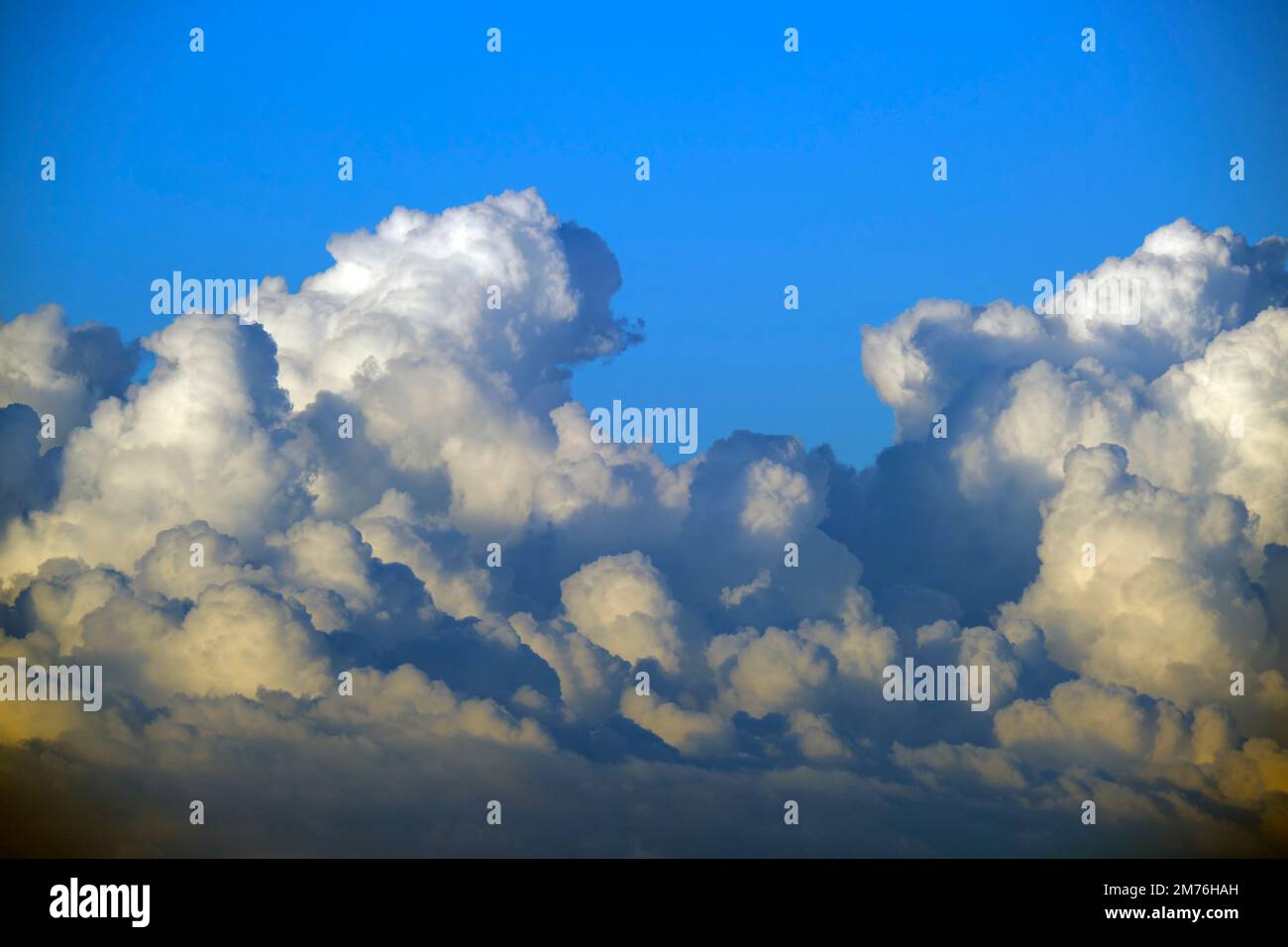 White fluffy cumulonimbus clouds forming before thunderstorm on summer ...