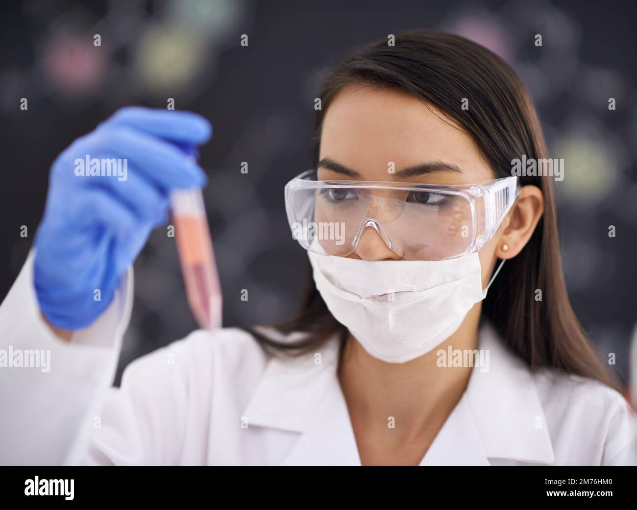 The science of genetics. a female scientist observing a sample in a ...