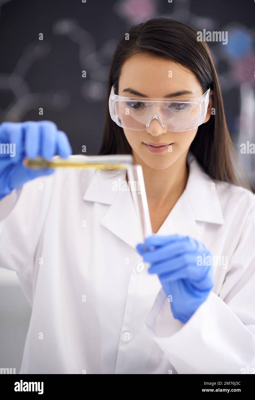 Dont spill a drop. a female scientist pouring liquid into a test tube ...