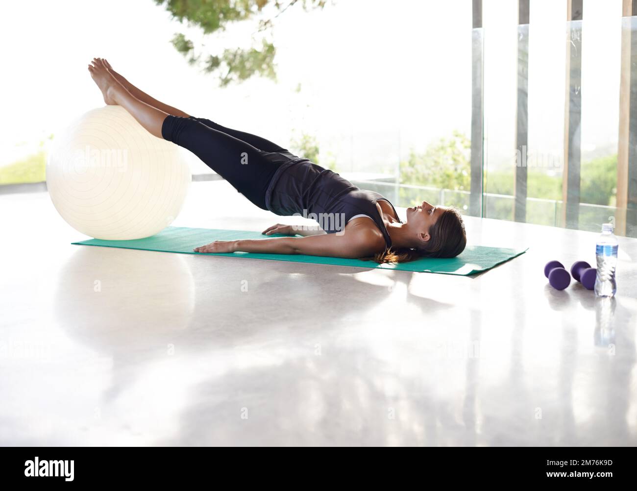 Toning her core. an attractive young woman working out in a studio with ...