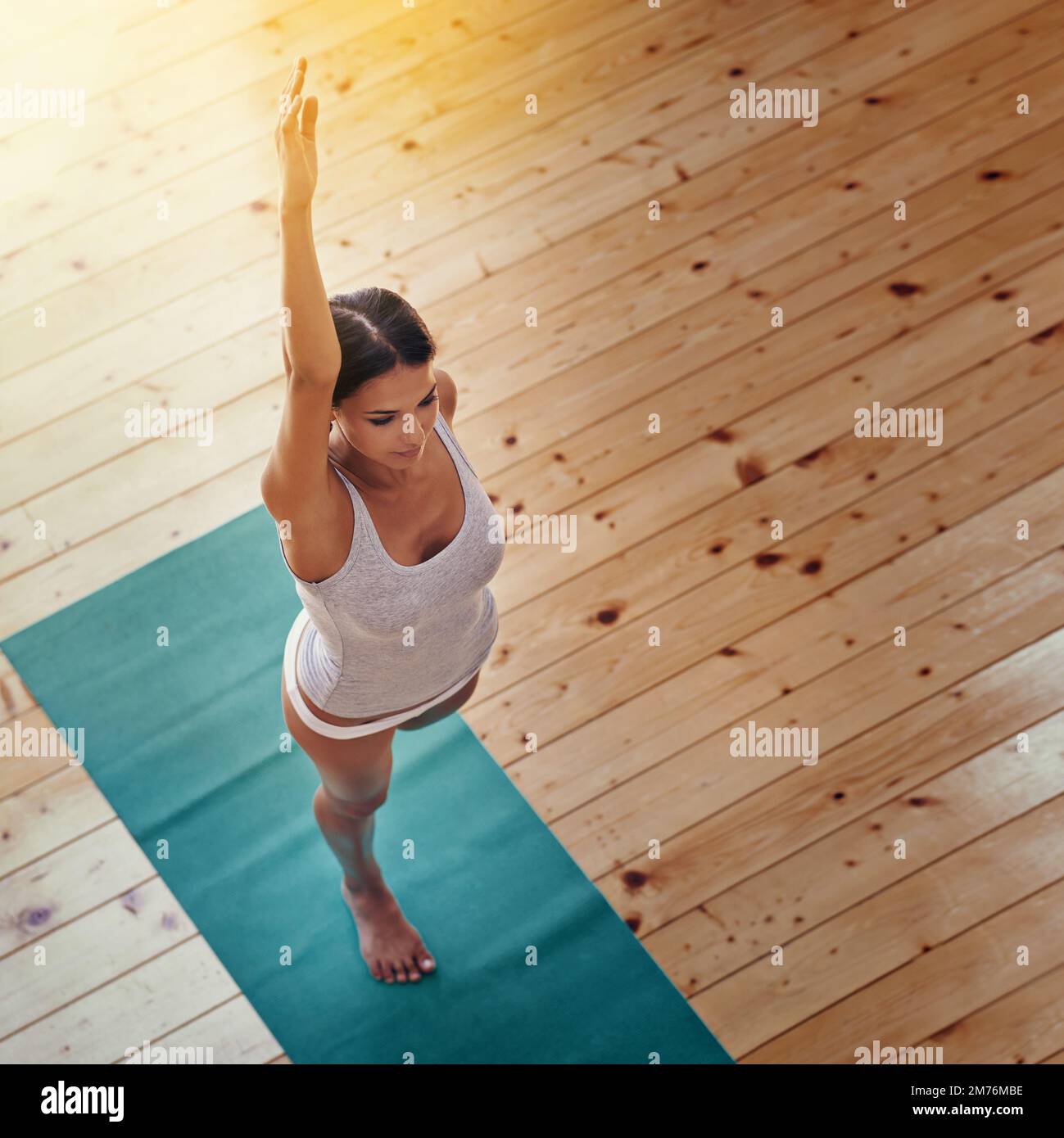 Perfect ing her form. High angle shot of a young woman doing yoga ...