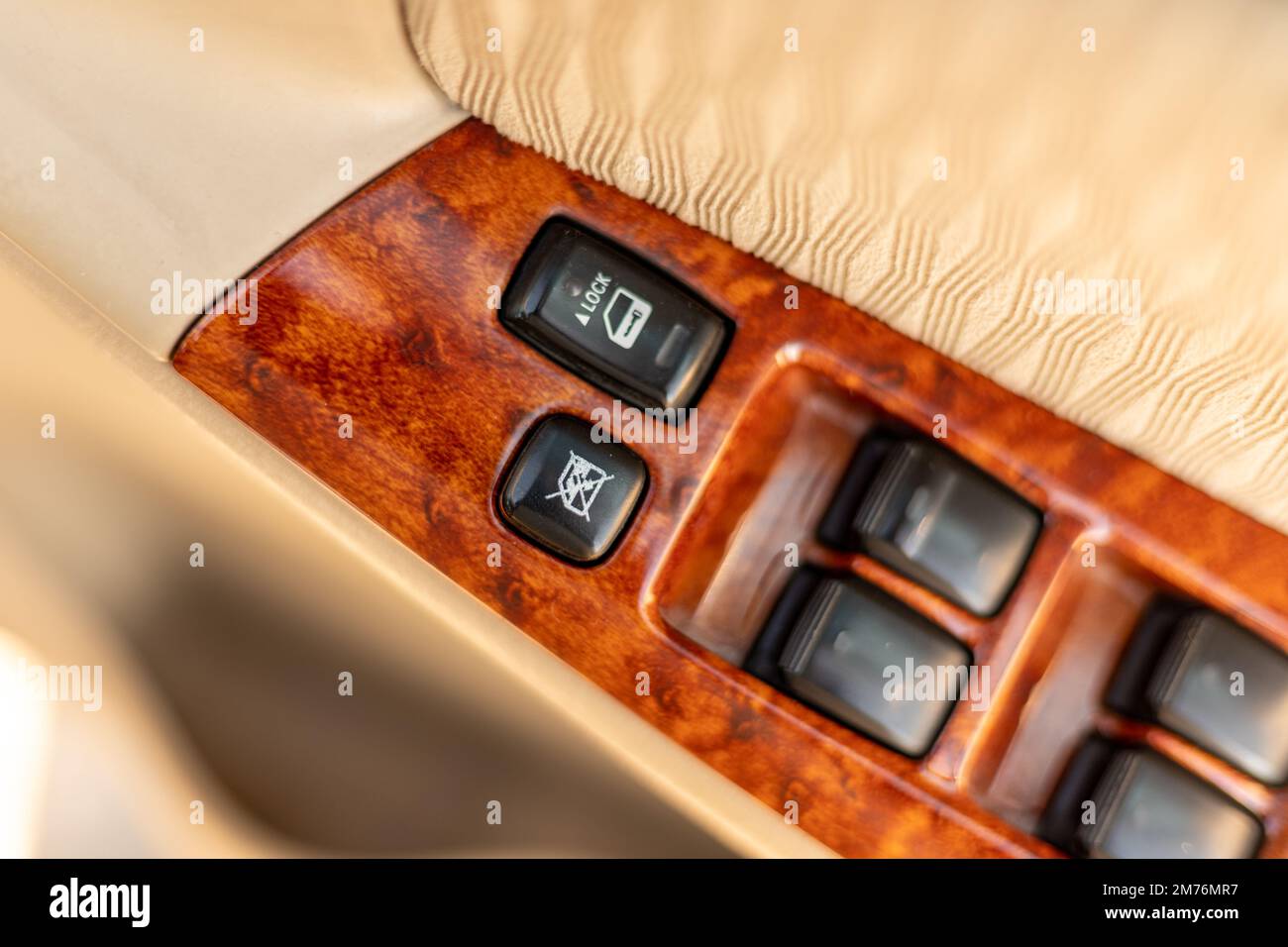 Car's window lock and unlock button on the arm of a driver side door ...