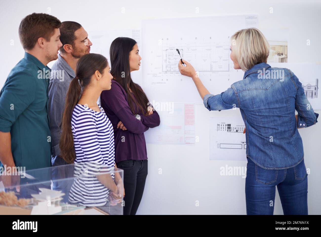 Familiarising themselves with every aspect of the plans. a group of ...