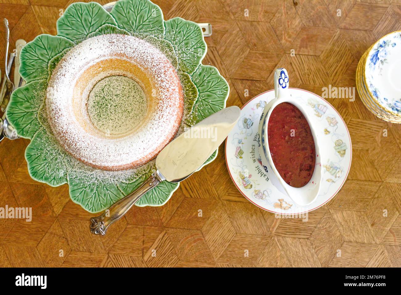 Round sponge cake with a fine dusting of white powered sugar sitting of ...