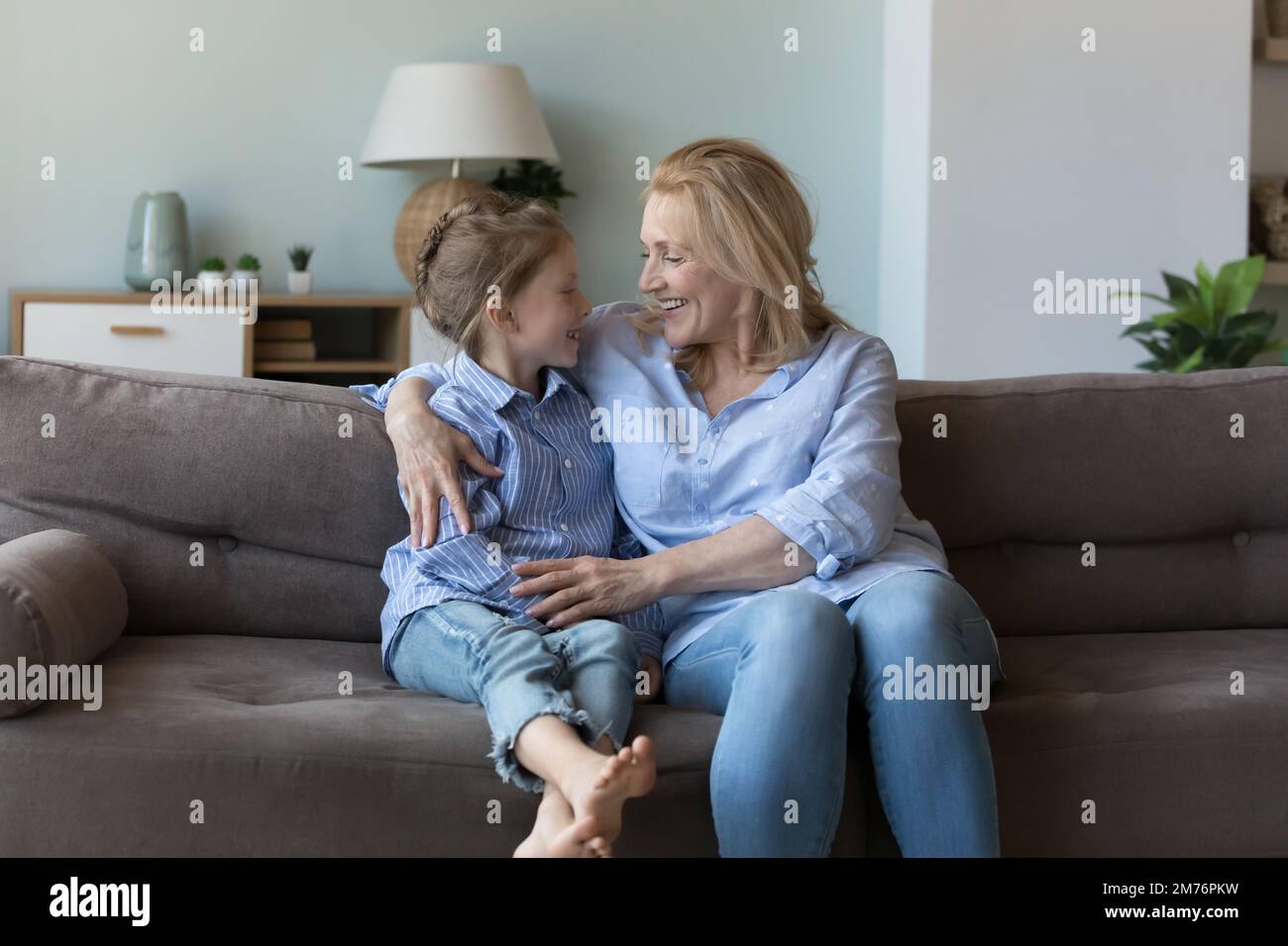 Happy pretty middle aged granny talking to cute granddaughter kid Stock ...