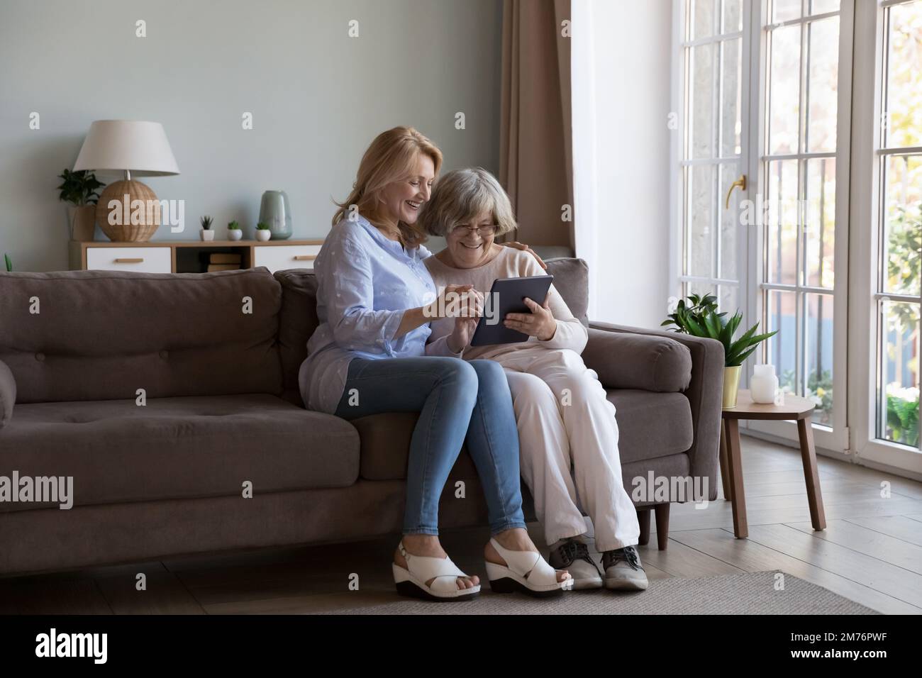 Cheerful positive elderly mother and daughter making payment Stock ...