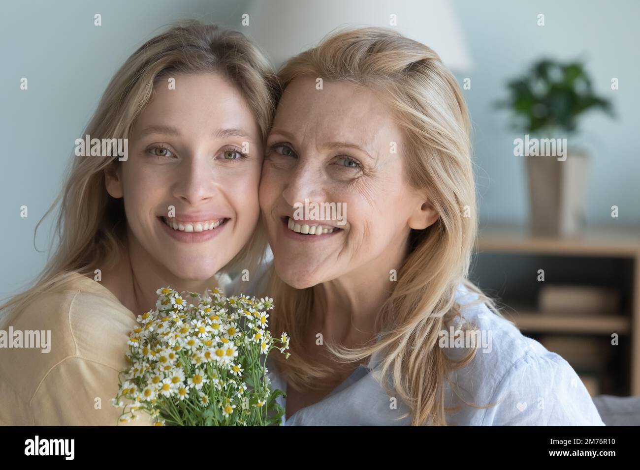 Happy Adult Daughter And Senior Blonde Mom Posing With Smiles Stock