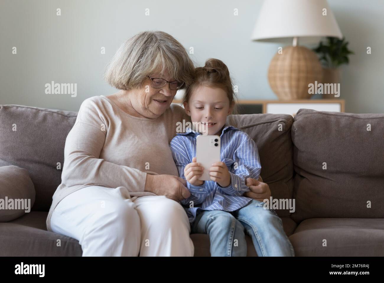 Old great grandma watching grandkid girl at home Stock Photo - Alamy