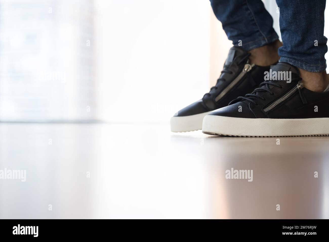 Unknown man in sneakers standing on floor indoors, close up Stock Photo ...