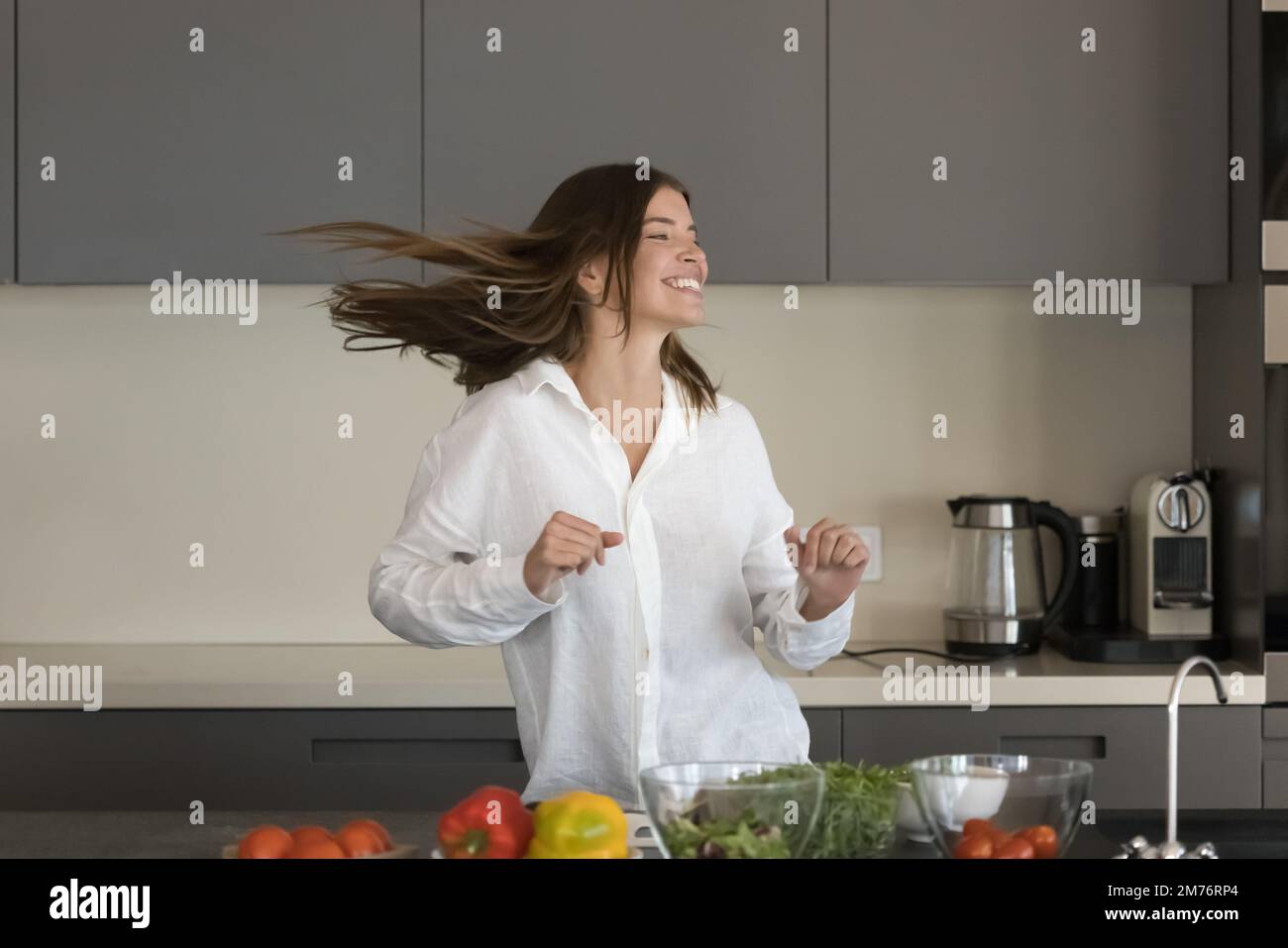 Happy beautiful woman dancing alone in modern kitchen Stock Photo - Alamy