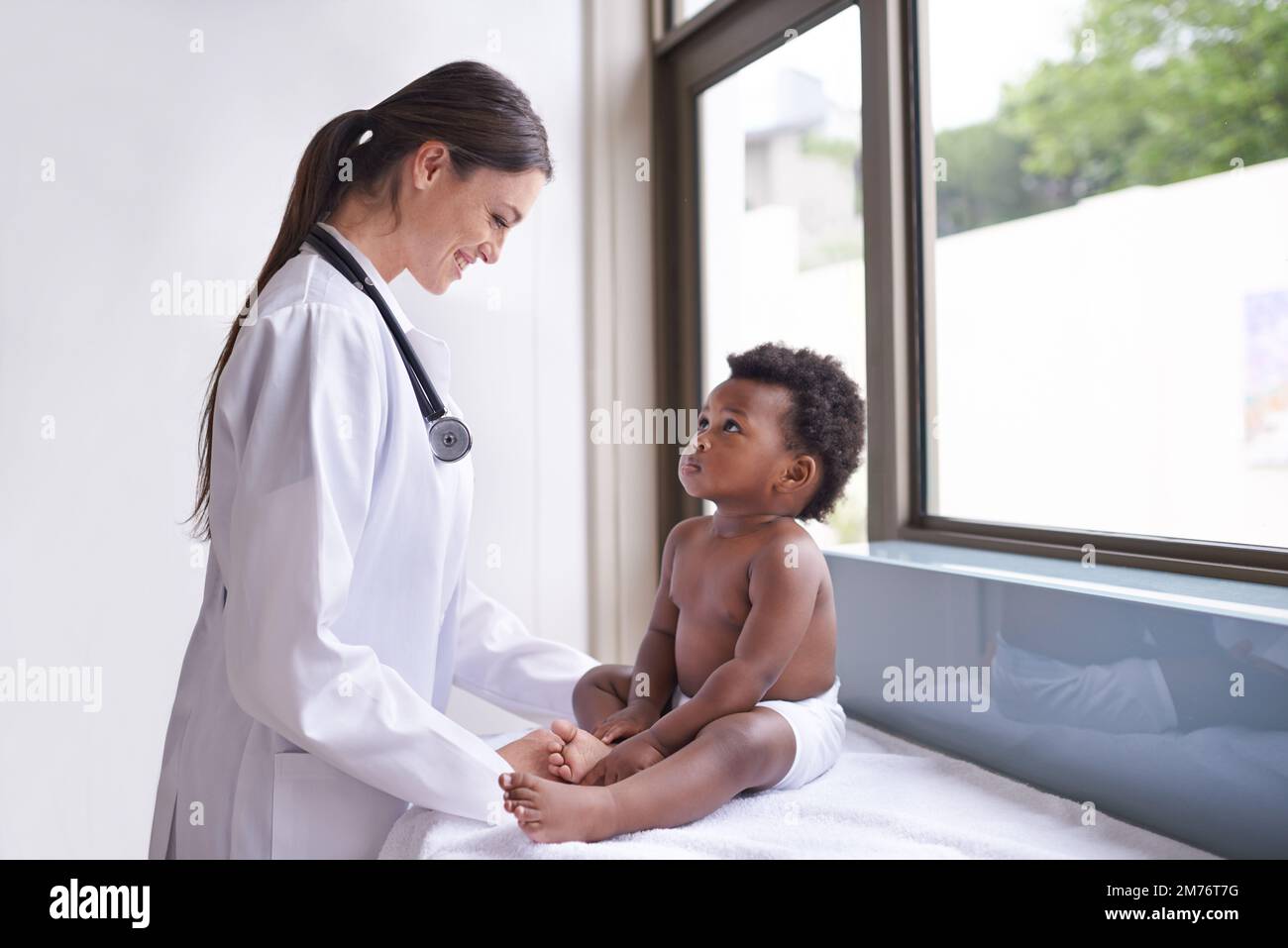 Just in for a routine pediatric checkup. a female pediatrician doing a ...