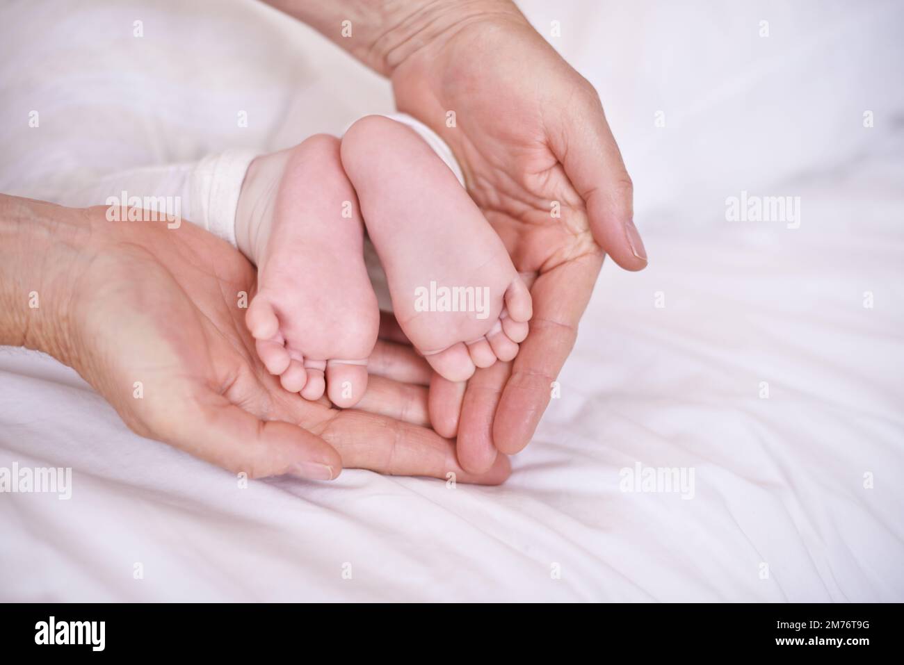 Safe in daddys embrace. a father holding his infant childs feet Stock ...