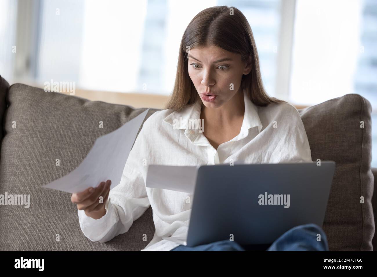 Woman looks shocked due to high utility bills Stock Photo - Alamy