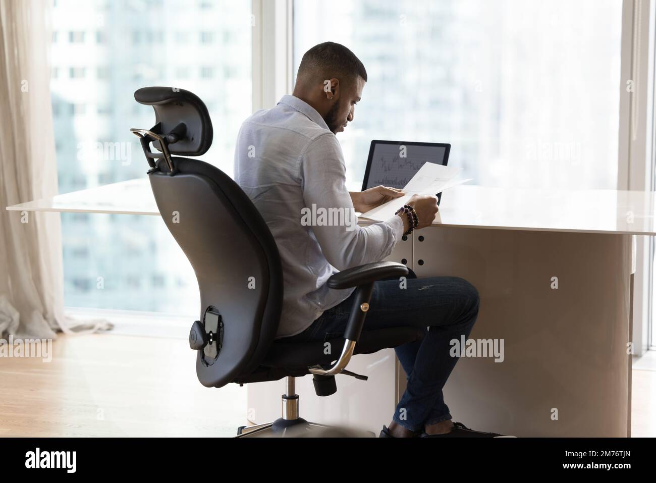 African sales manager, financial reviewing statistical data at ...