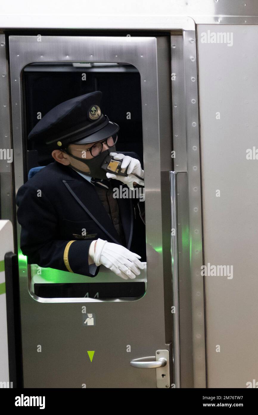 Tokyo, Japan. 6th Jan, 2023. A conductor train crew member as commuters ...