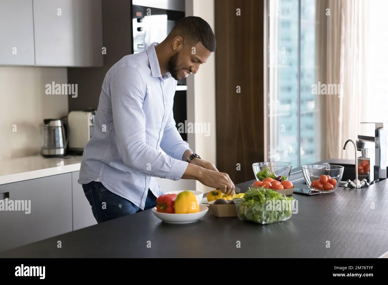 Happy African guy cooking in the kitchen Stock Photo - Alamy