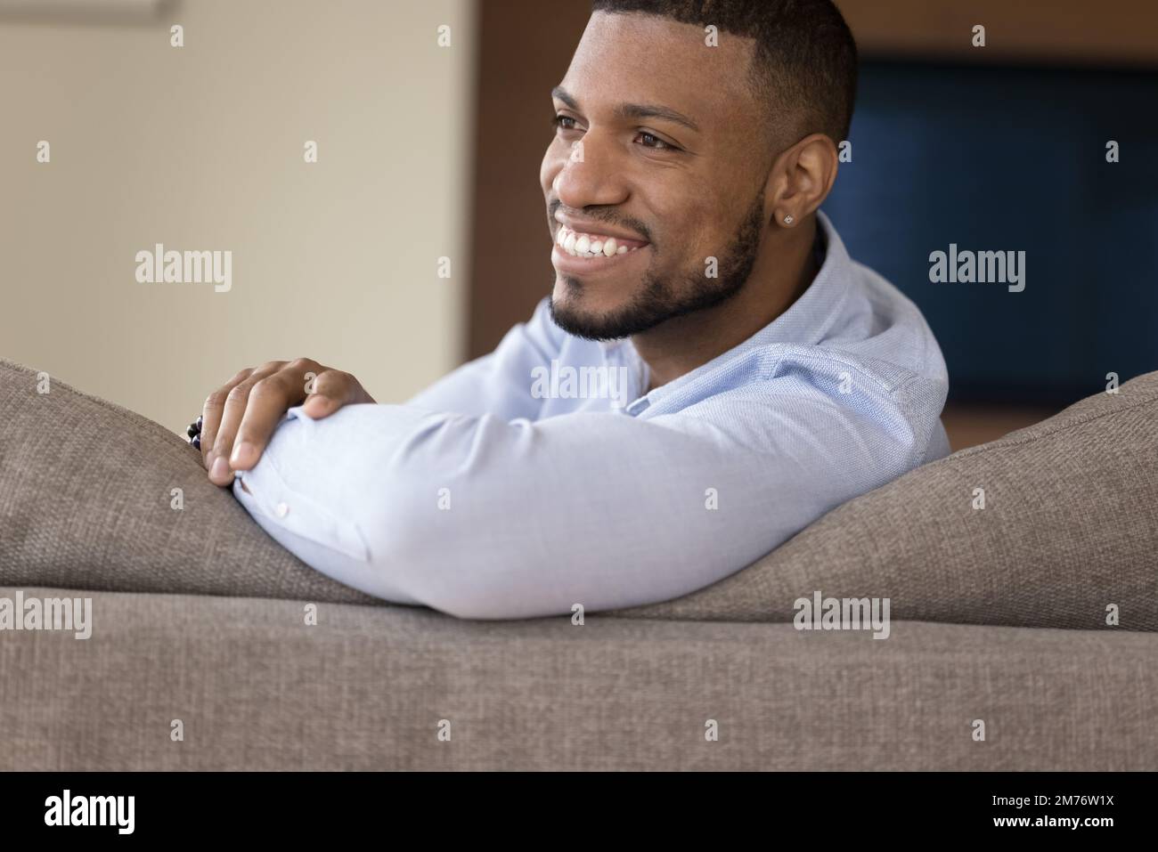 Smiling African man resting on couch at home on weekend Stock Photo - Alamy