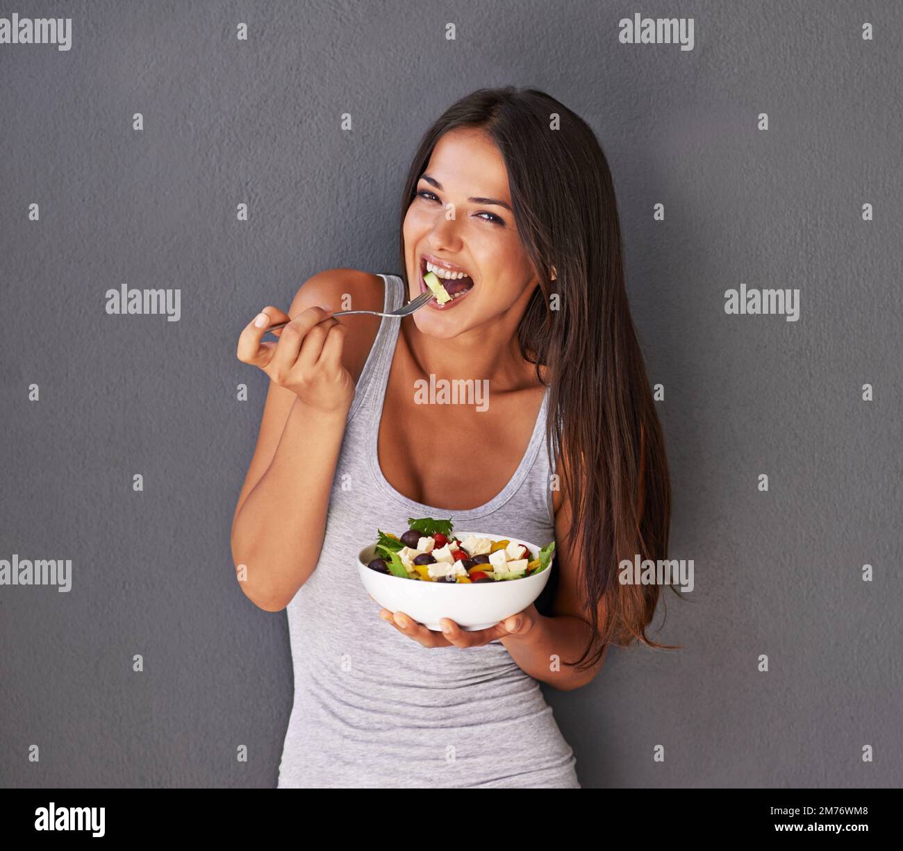 Bites of freshness. Portrait of a healthy young woman eating a salad ...