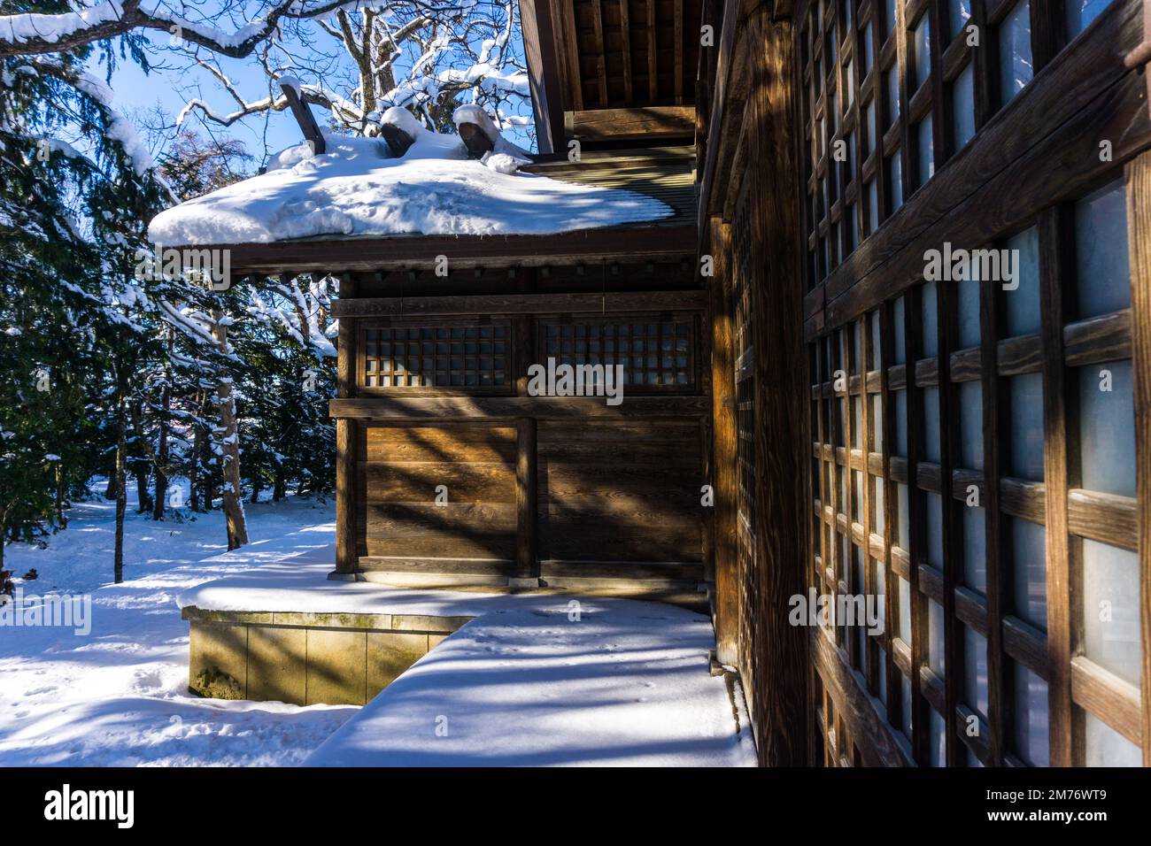 Snowy Japanese shrine building at Higashikawa Shrine on a sunny winter ...