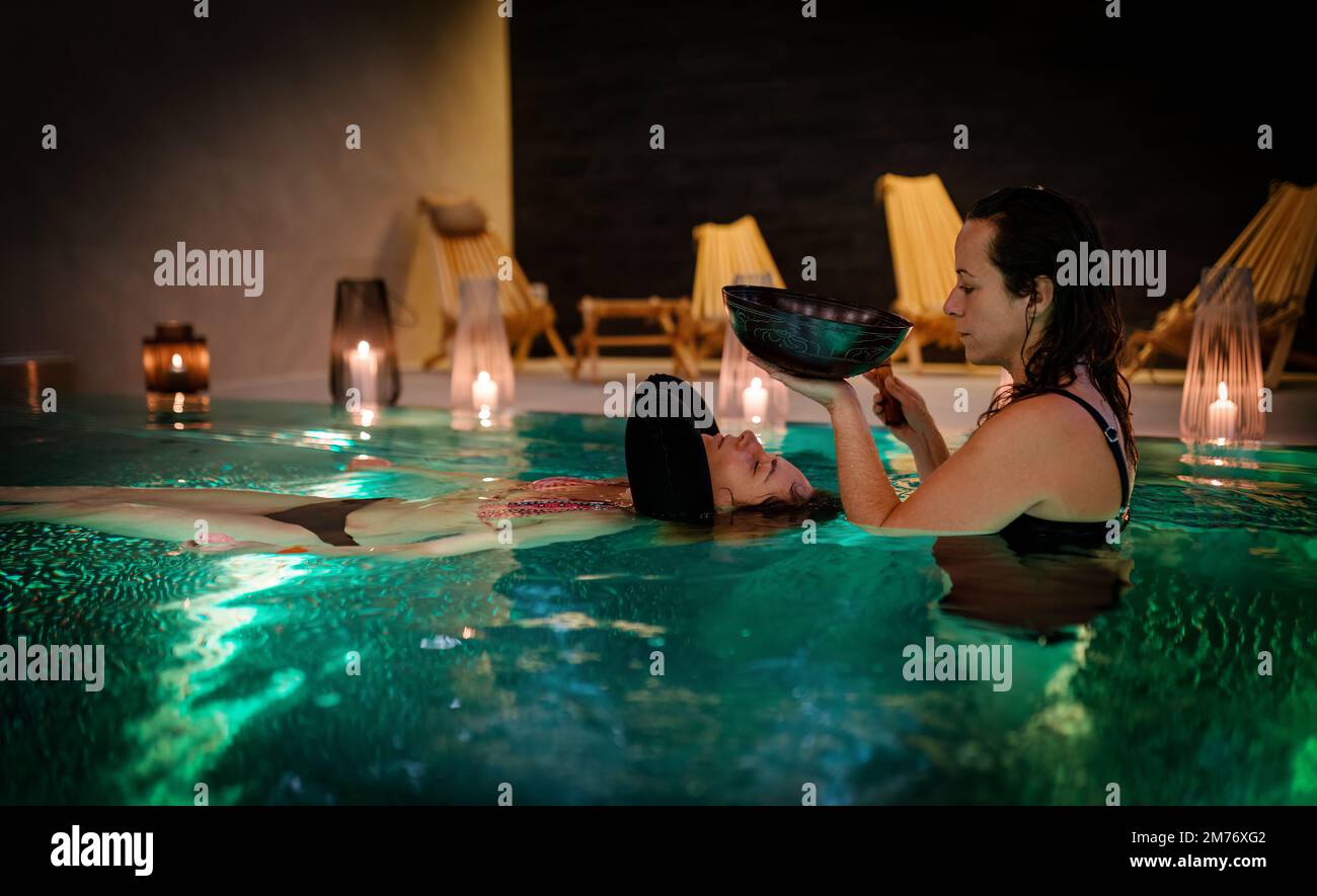 Therapeutic exercise in the pool. Woman receiving an aquatic therapy in ...