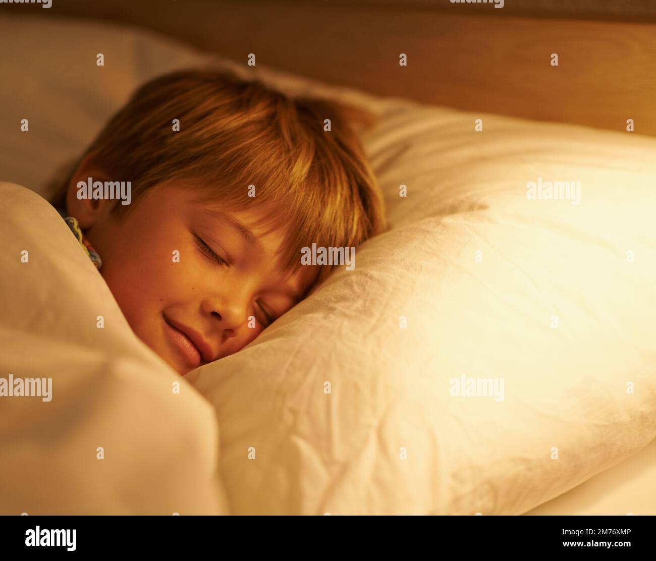 Dream a happy little dream. a young boy sleeping in bed Stock Photo - Alamy