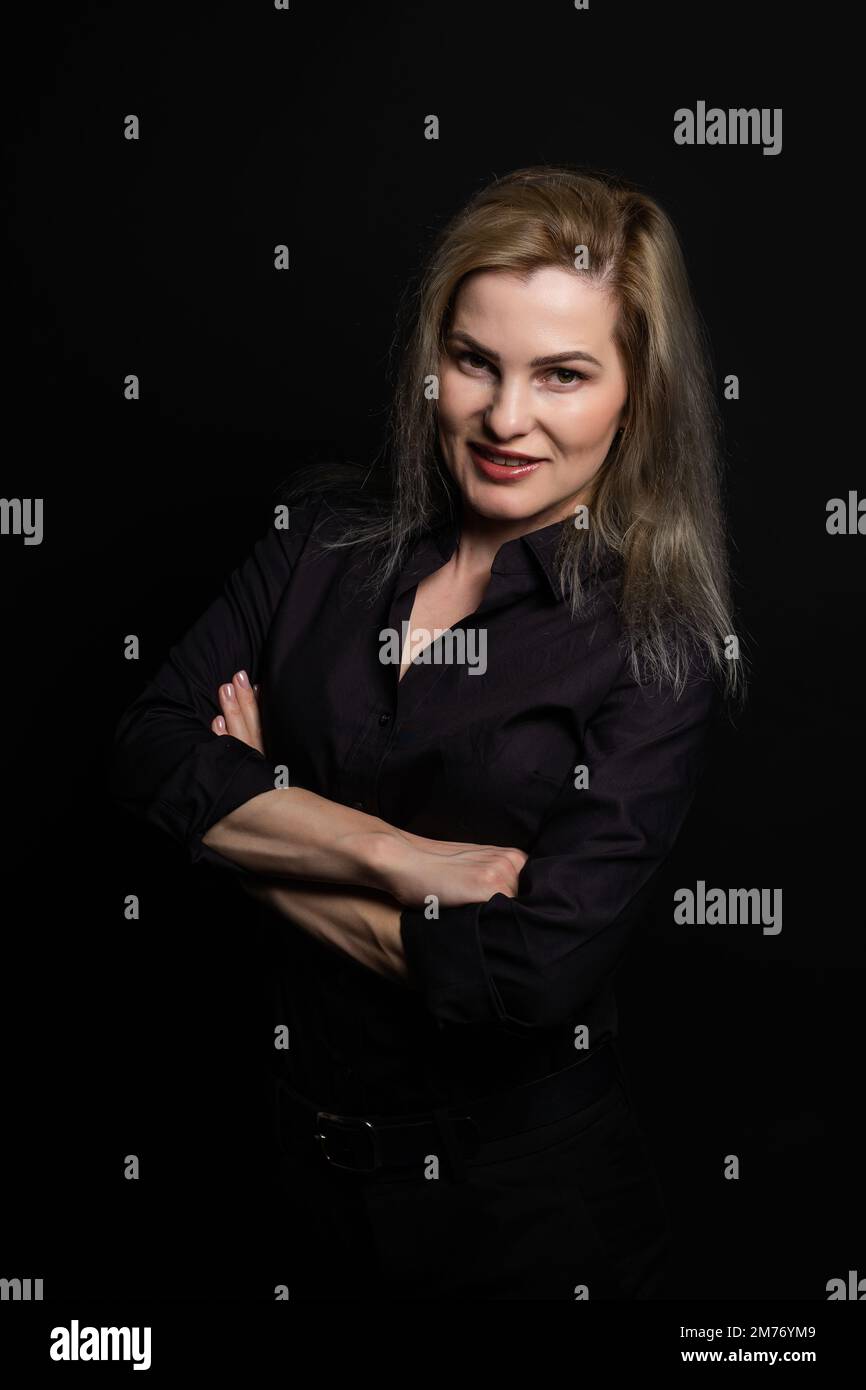 Elegant blonde beautiful middle aged lady posing, smiling to the camera ...