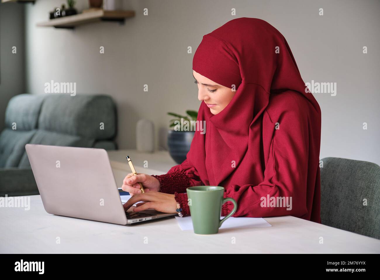 Muslim young woman student in hijab using laptop at home Stock Photo ...