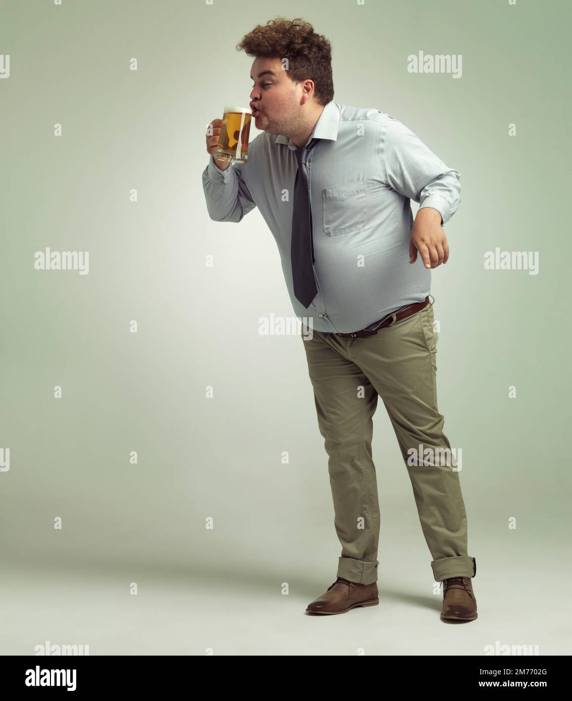 Bliss in that first sip. an overweight man sipping a pint of beer Stock ...