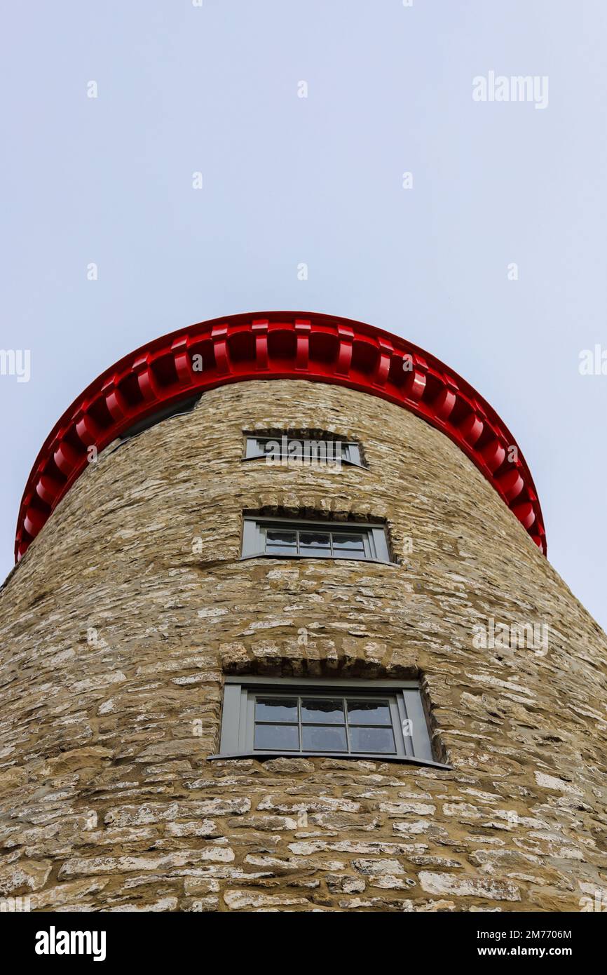 Old stone lighthouse - details. Red roof, wooden windows and natural ...