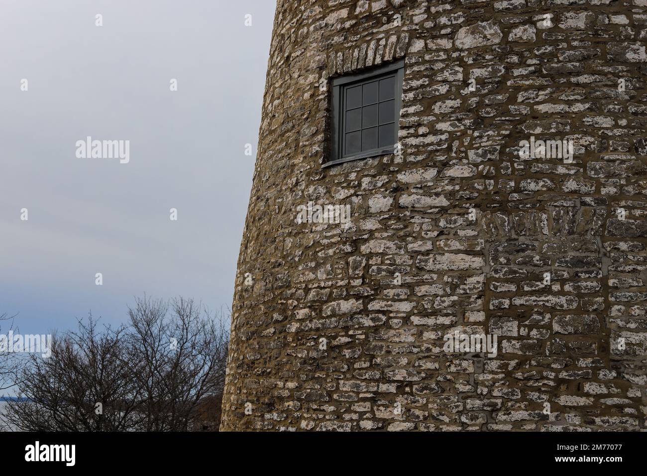 Old stone lighthouse - details. Red roof, wooden windows and natural ...