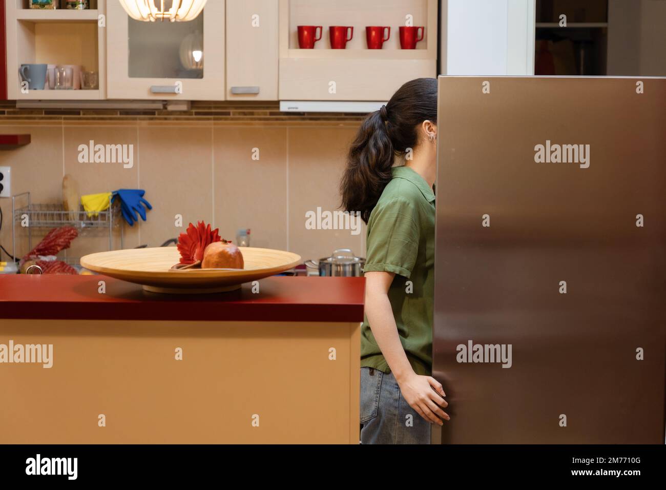 Night hunger. Side view of unrecognisable woman takes food from frige ...
