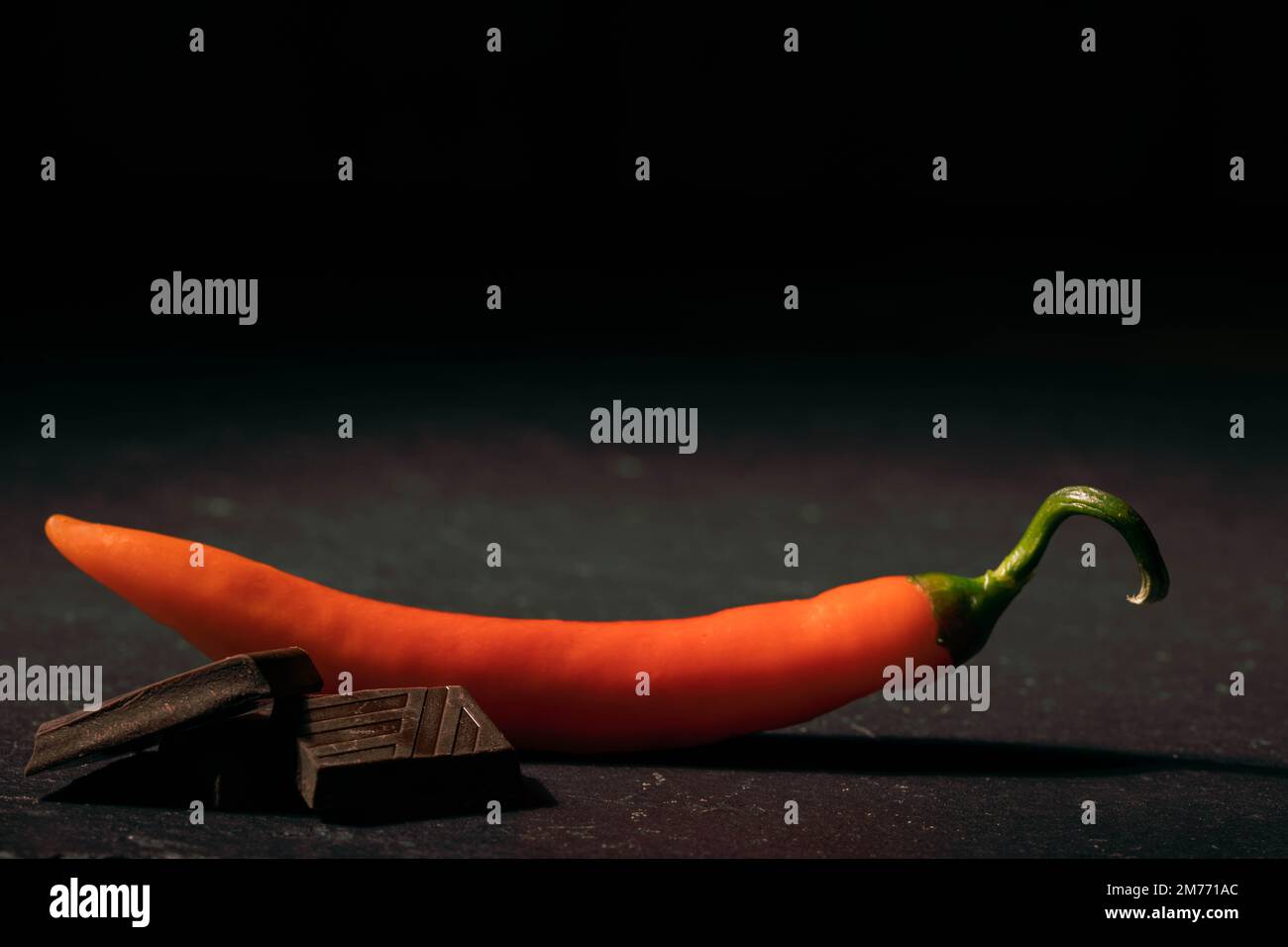 chilli and chocolate on a black background Stock Photo - Alamy