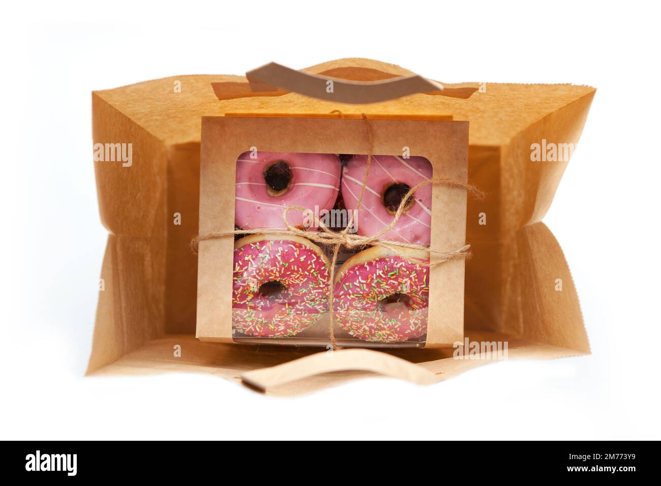 Pink donuts packed in box in craft bag isolated on white background ...