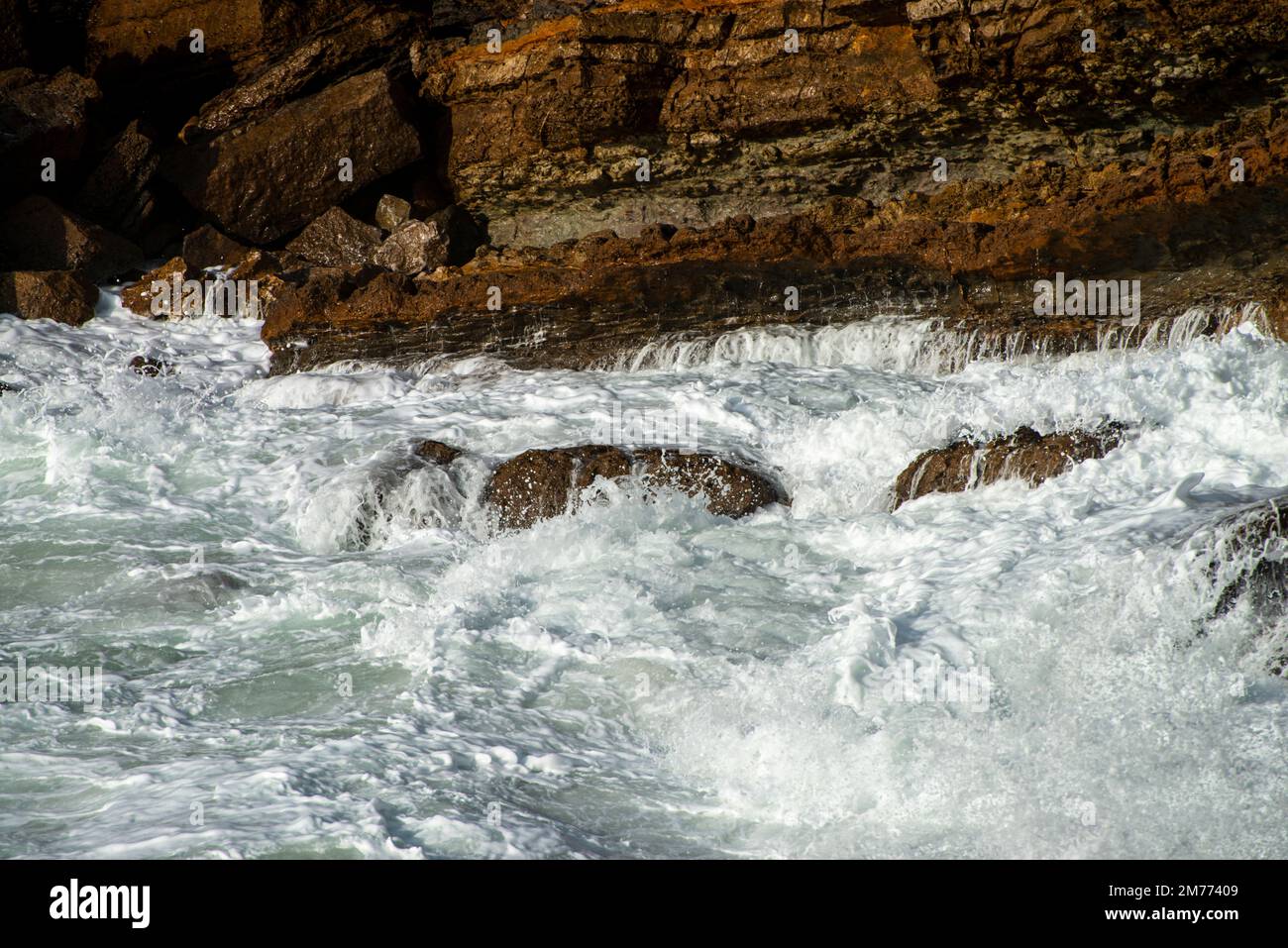 Atlantic Ocean waves crash into dramatic layered rock formations near ...