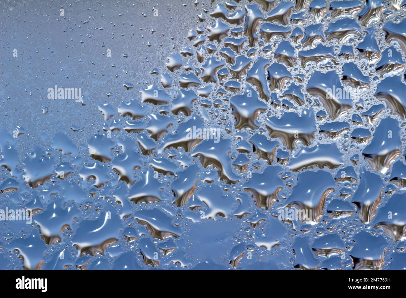 Macro abstract texture background of water droplets and ice forming on an interior glass window ...