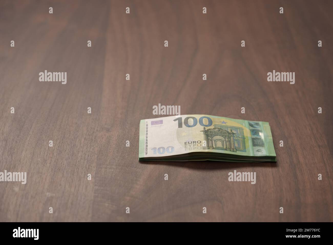 Hundred euro banknotes on a walnut table. shallow focus Stock Photo - Alamy