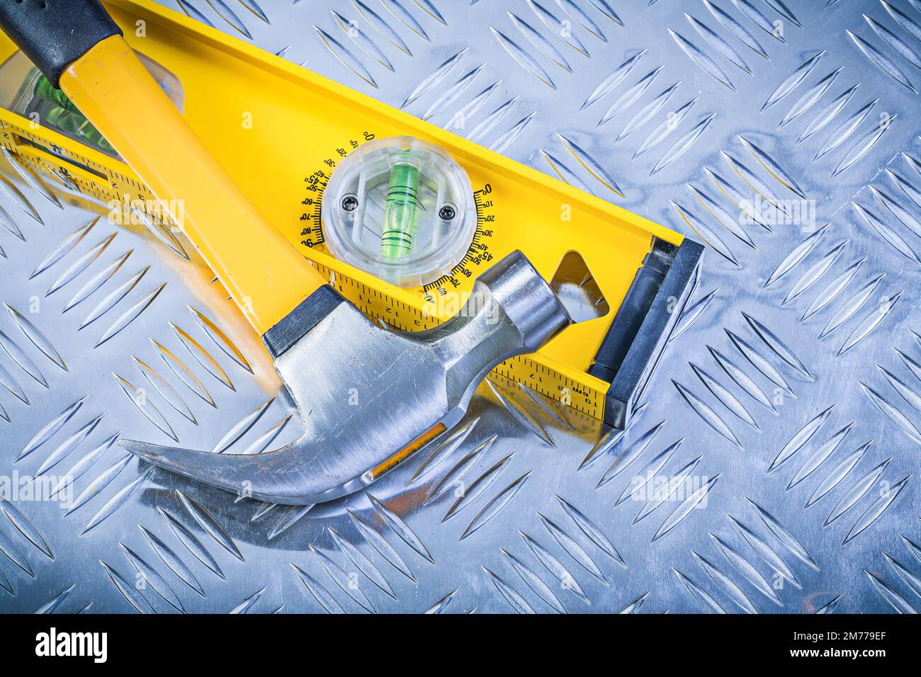 Claw hammer construction level on grooved metal plate Stock Photo - Alamy