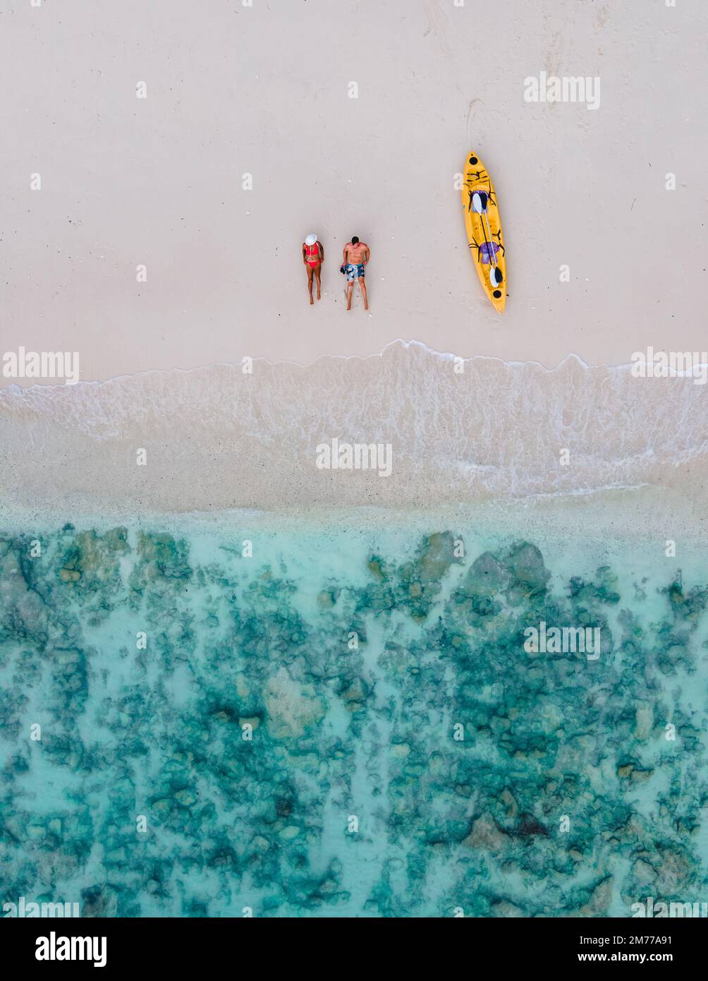 Drone View At Couple Laying Down On The Beach Of Koh Phi Phi Thailand During Vacation With Kayak