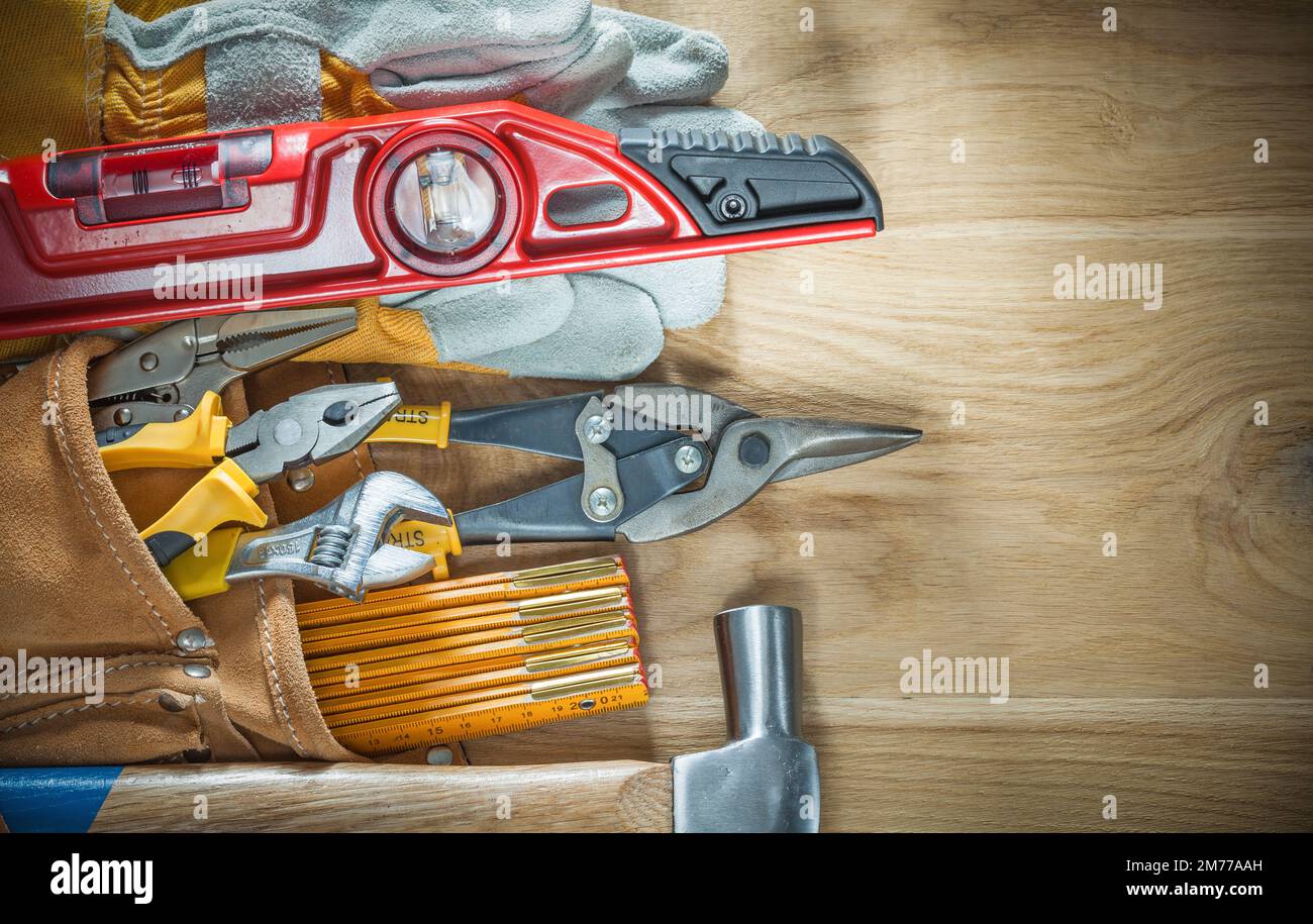 Collection of construction tooling in building belt on wood board Stock ...