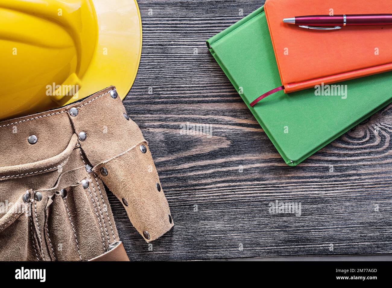 Collection of tool belt notepads pen building helmet on wooden board ...