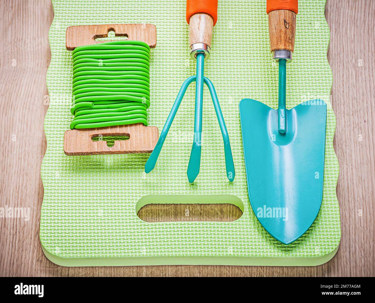 Metal hand spade rake garden soft tie foam kneeling pad on wooden board ...