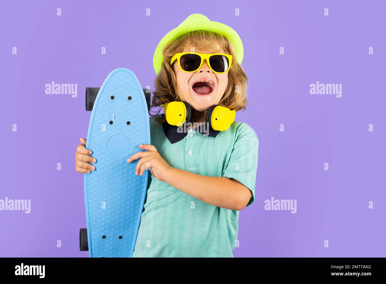 Funny happy kid in casual wear holding longboard looking happy and ...