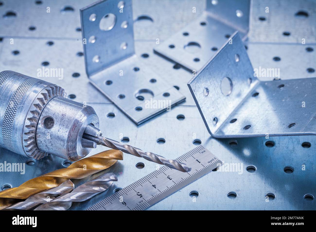 Metal ruler drill boring bits and angle bars on perforated metallic ...