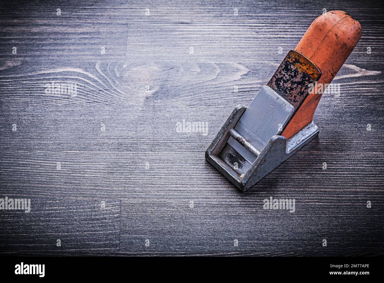 Mini vintage block shaving plane on wood board construction concept ...