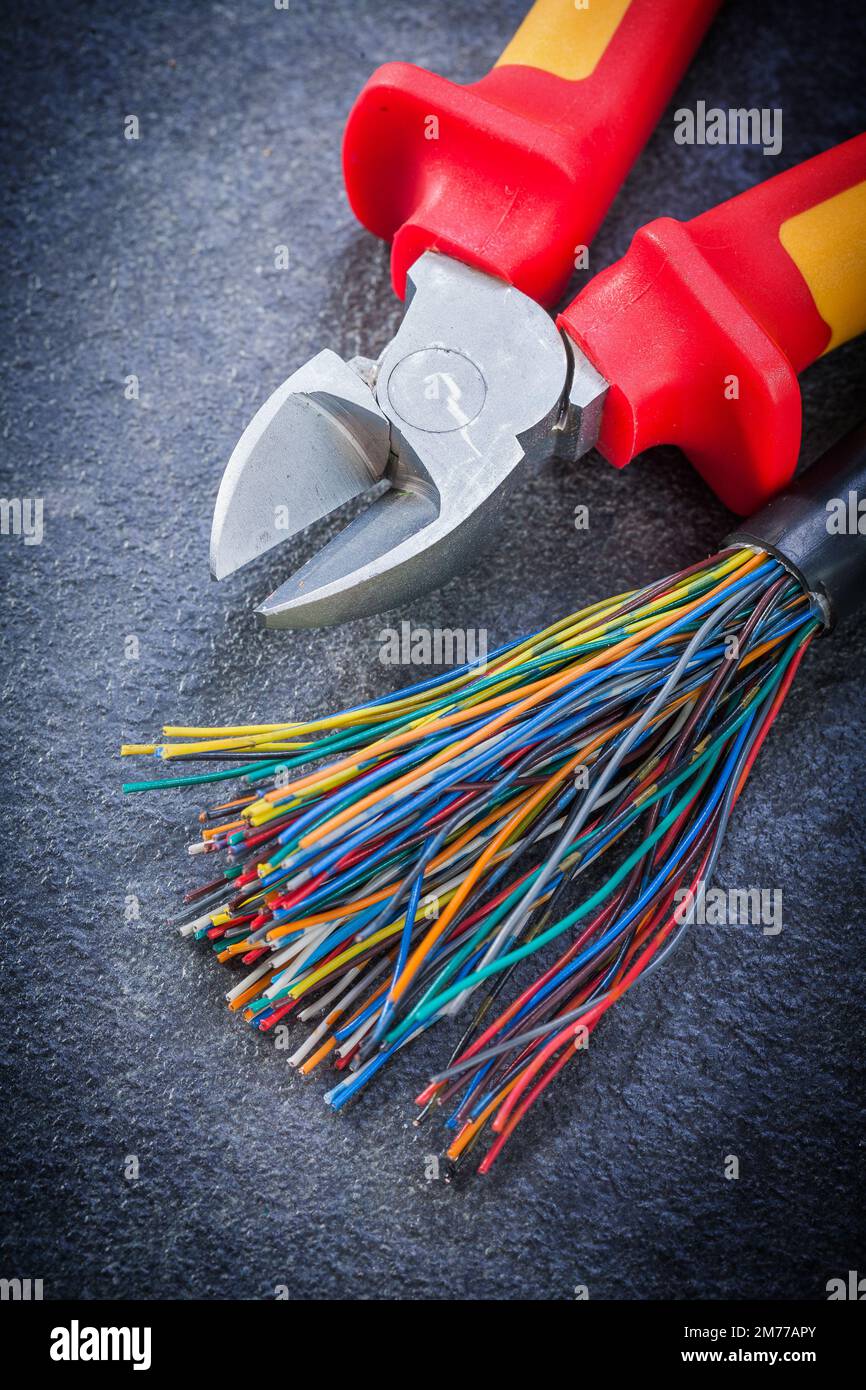 Multicolored electric wires nippers on black background electricity ...