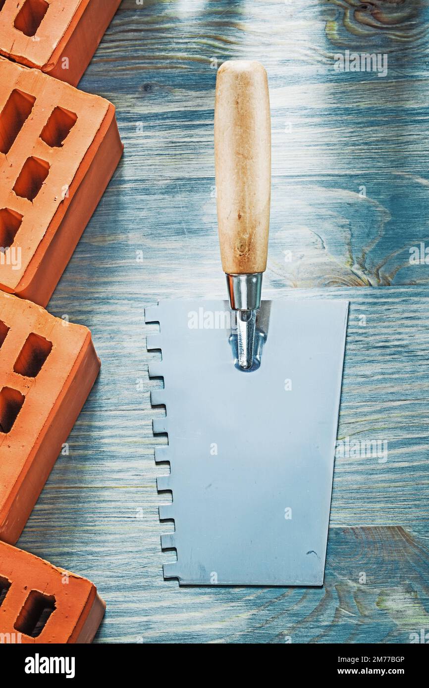 Orange bricks construction spatula on wooden board bricklaying concept ...