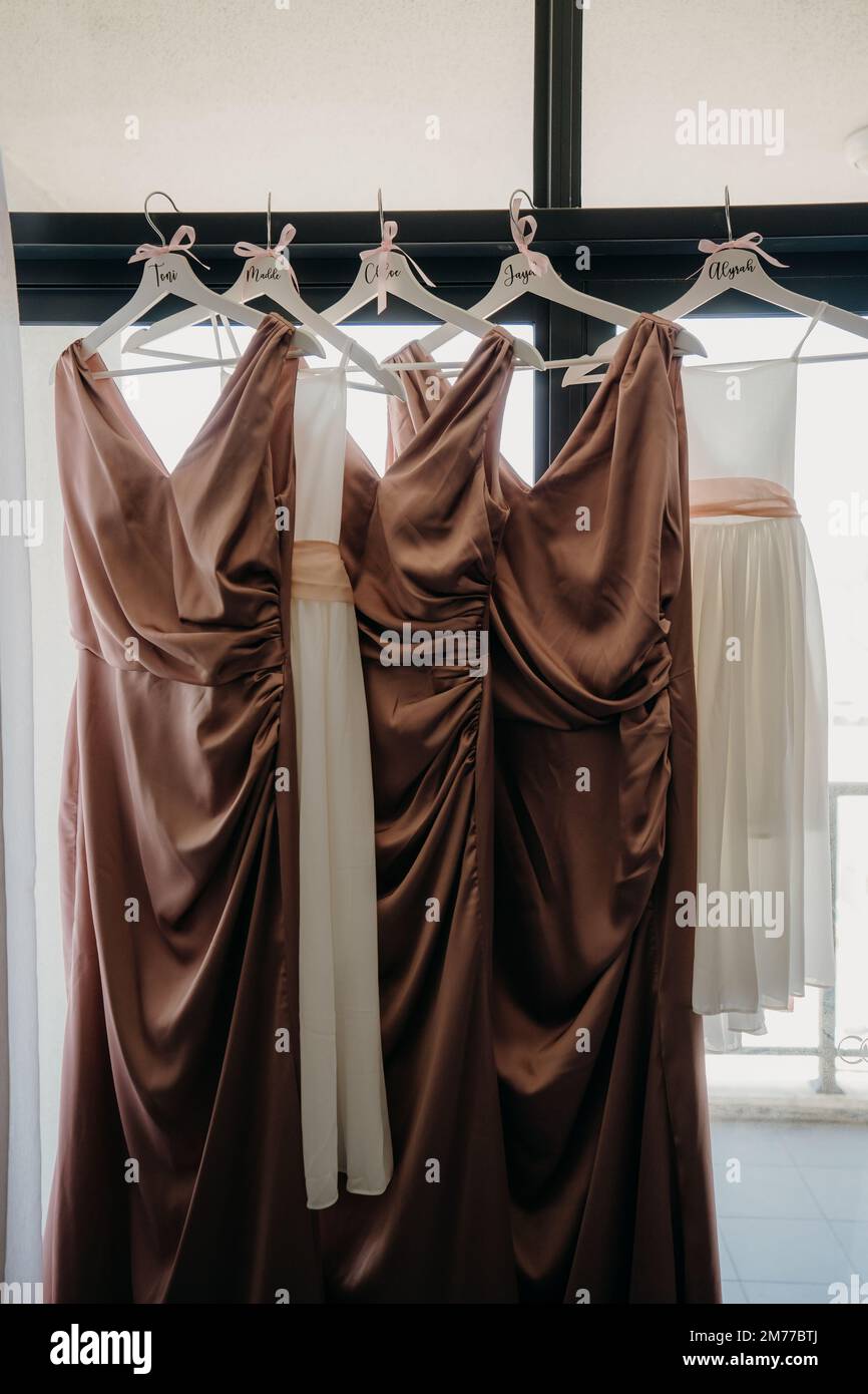 A vertical shot of matching bridesmaids dresses with named hangers ...