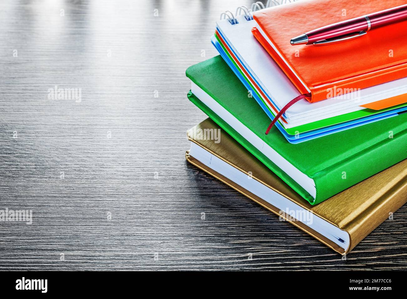 Pile of notebooks pen on wooden board Stock Photo - Alamy
