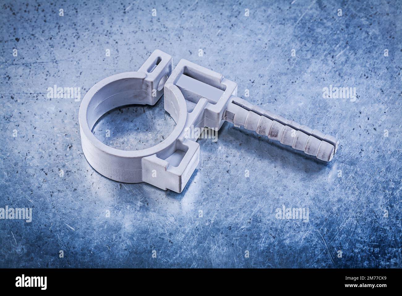 Plastic pipe clamp on metallic background construction concept Stock ...